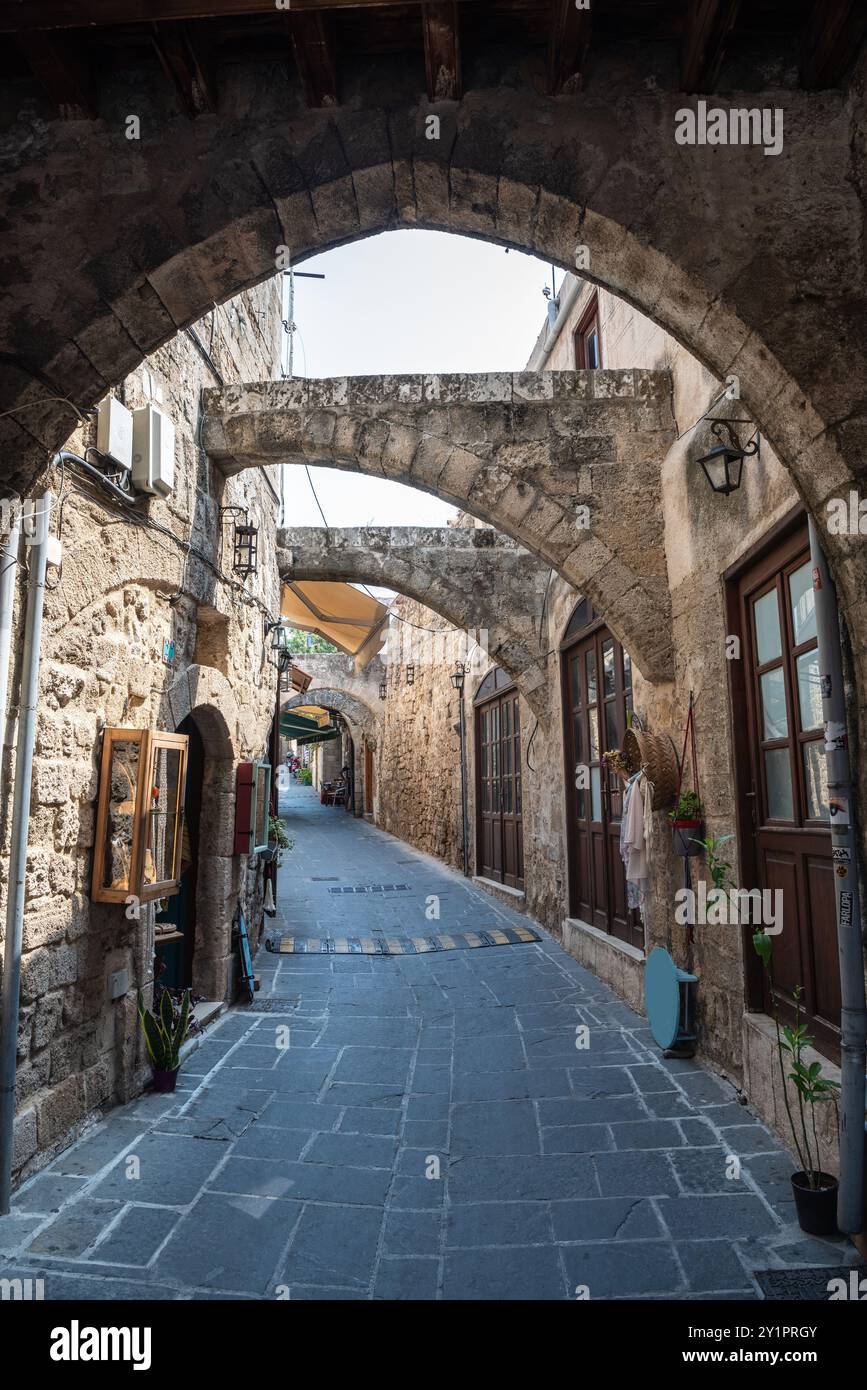 Narrow alley (Pythagoras street) with stone arches in the medieval town ...