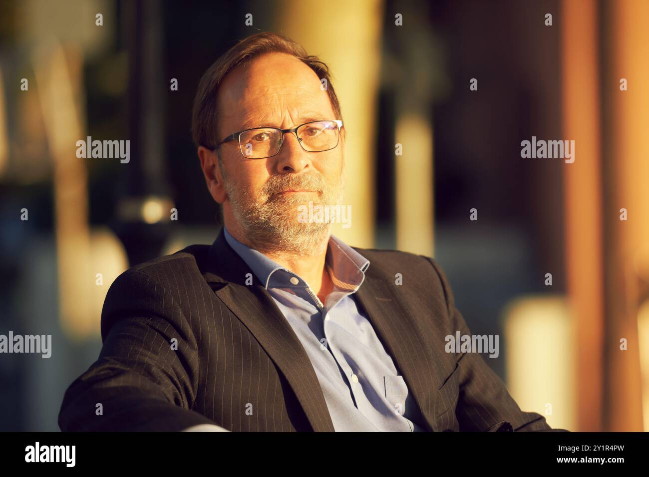 Outdoor portrait of handsome middle age man wearing suit, posing in ...
