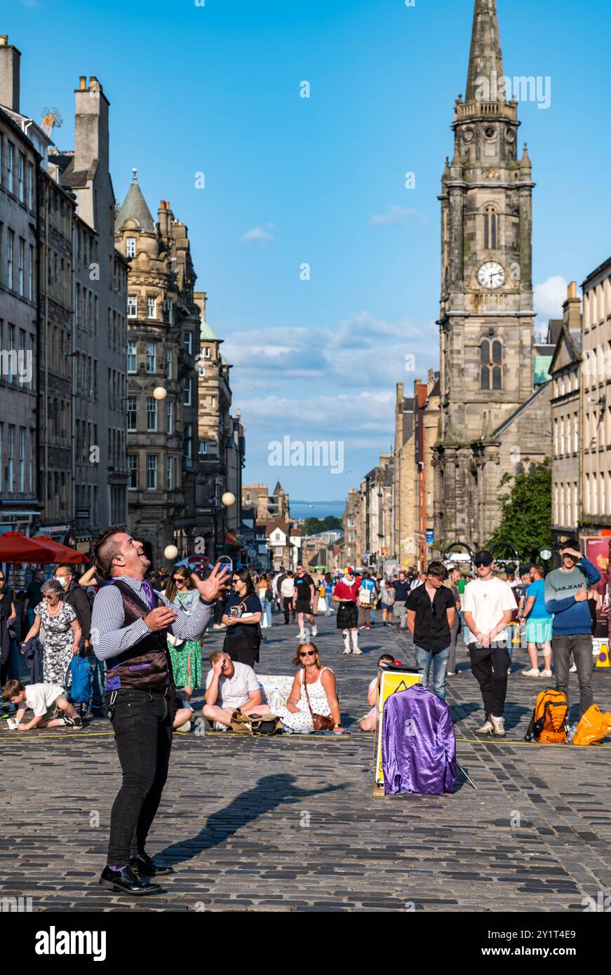 Crowd on Royal Mile watching street performer juggling balls during ...
