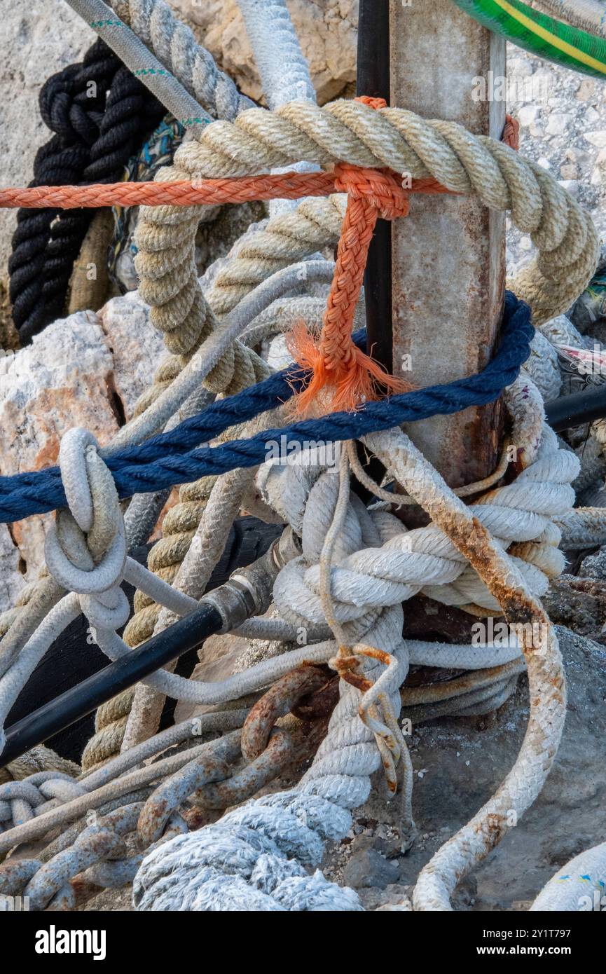 tangled ropes wrapped around a wooden post, tangle of ropes and cordage ...