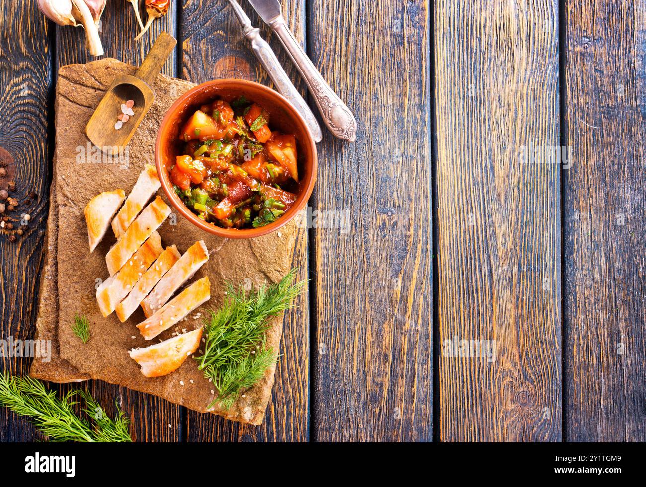 Baked chicken fillet on board with vegetable stew in bowl Stock Photo ...