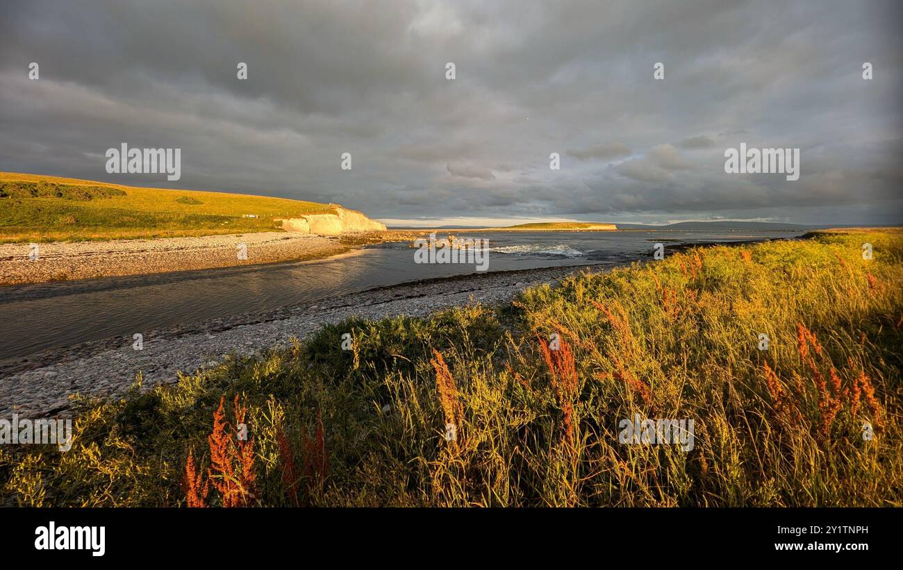 Dramatic coastal sunset landscape scenery with cliffs in background ...