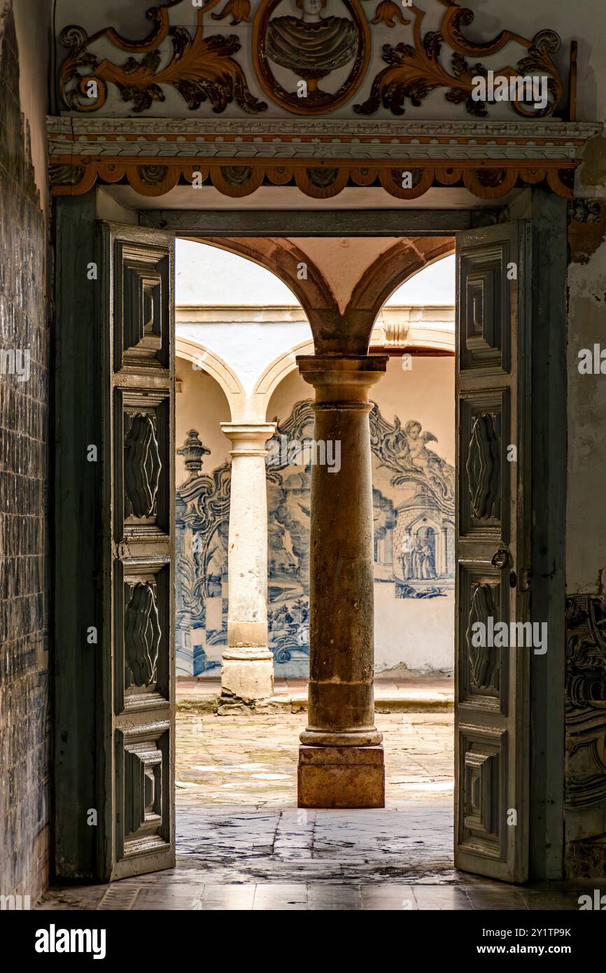 Wooden door inside an old baroque church open to its internal courtyard ...