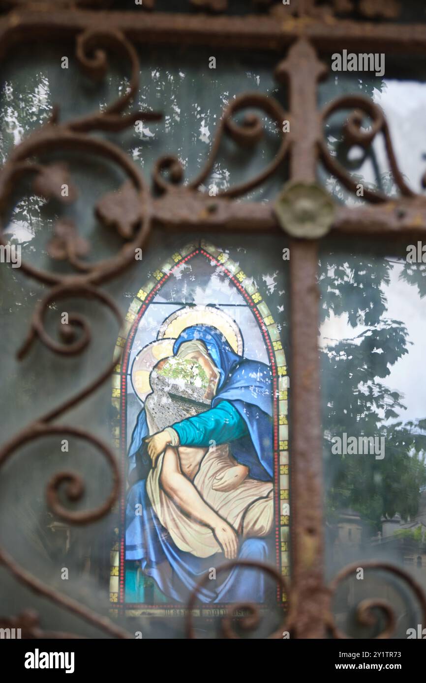 Stained glass window depicting the Virgin Mary holding the body of ...