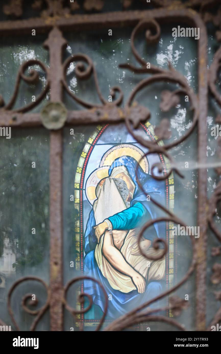 Stained glass window depicting the Virgin Mary holding the body of ...