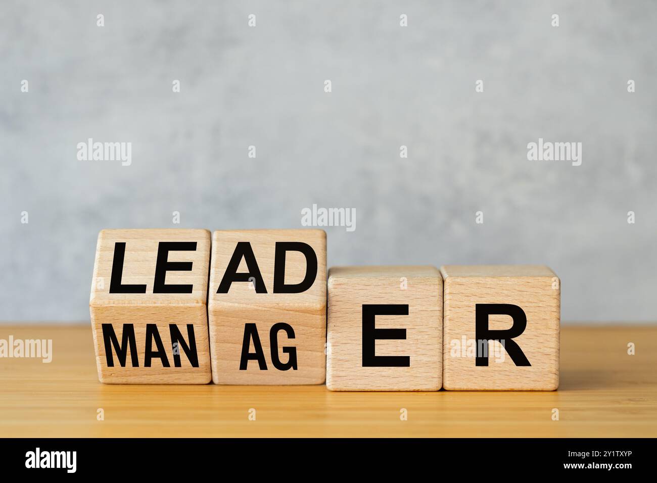 Manager vs leader symbol. Businessman arranged wooden cubes on the ...