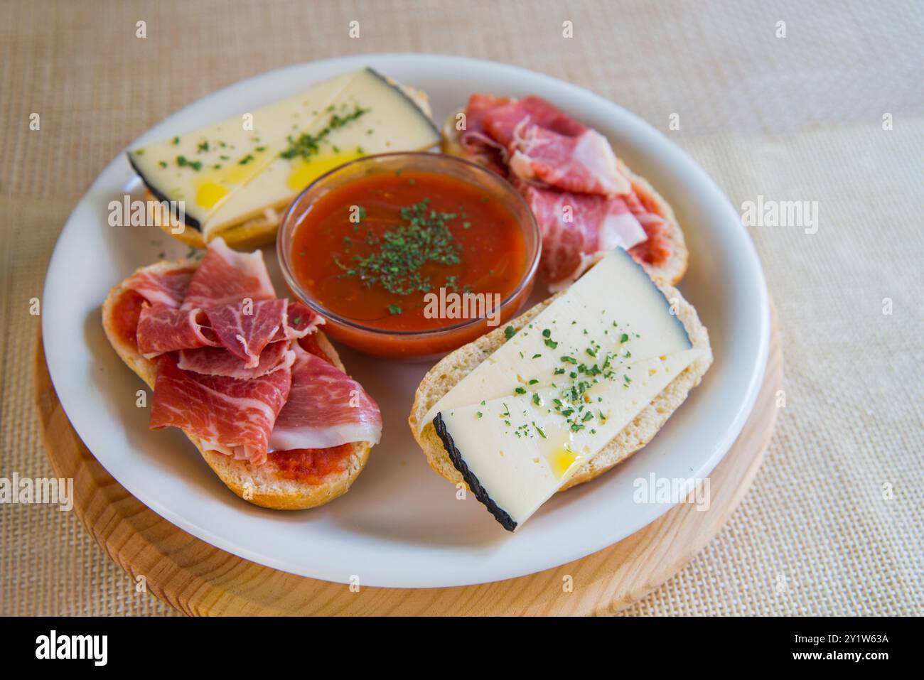 Assorted tapas: Iberian ham and Manchego cheese with tomato sauce Stock ...