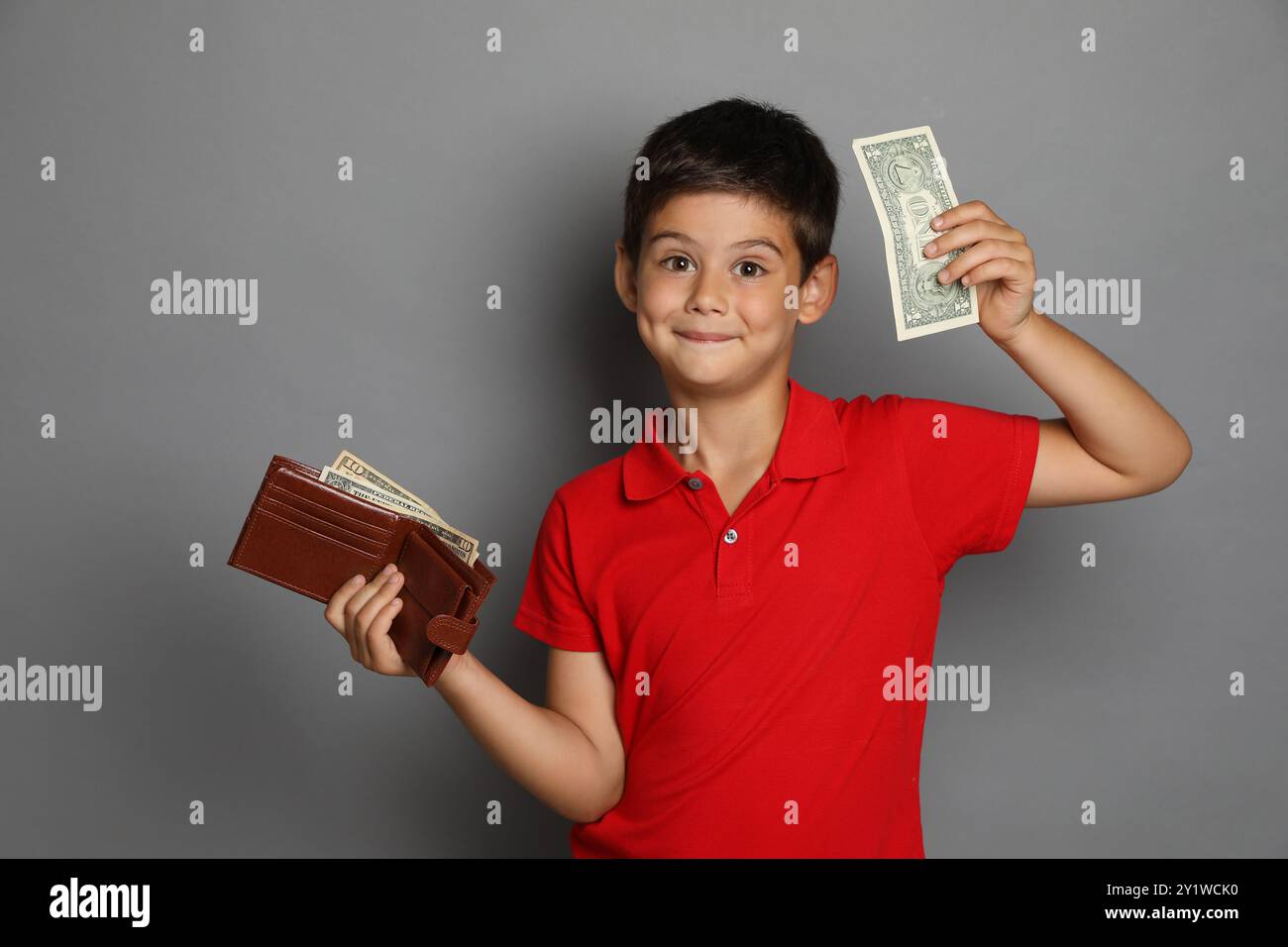Cute boy with wallet and pocket money on grey background Stock Photo ...