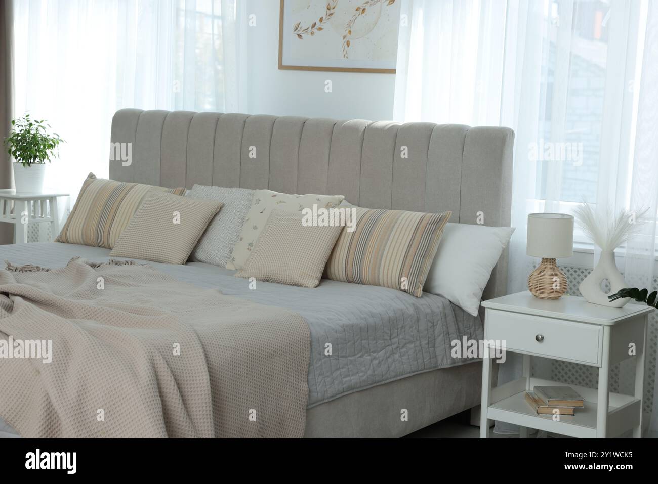 Big comfortable bed in room. Interior design Stock Photo - Alamy
