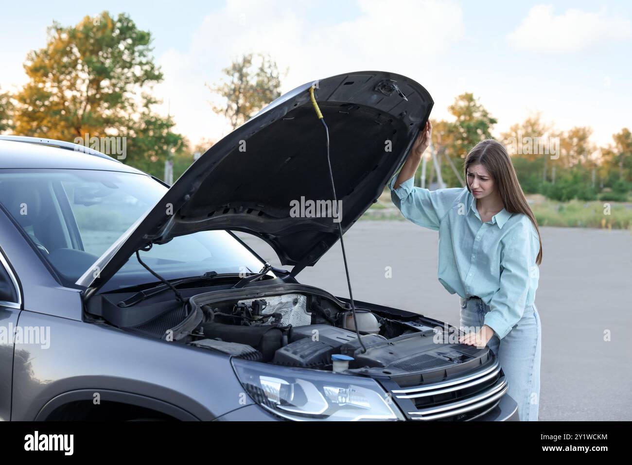 Woman looking under hood car hi-res stock photography and images - Alamy