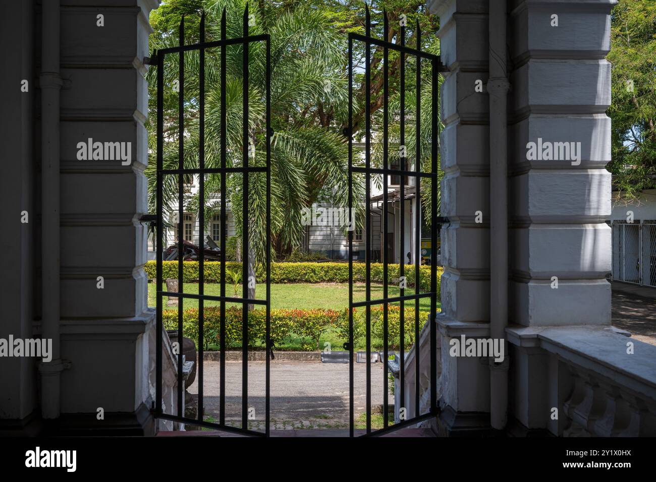 A photo looking through gates leading to the gardens of the Colombo ...