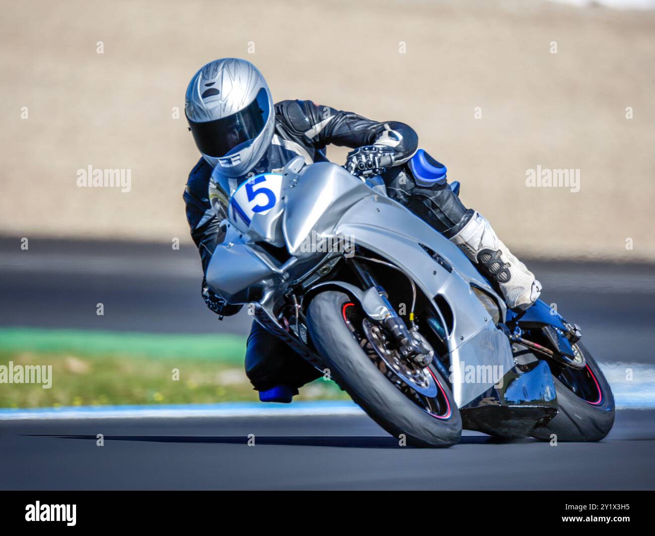 Dynamic action shot of a motorcycle racer in protective gear leaning ...