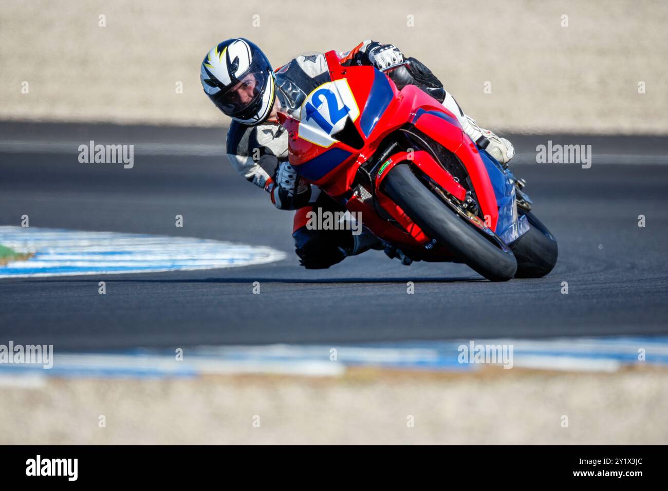 A motorcycle racer expertly leans into a sharp corner during a high ...