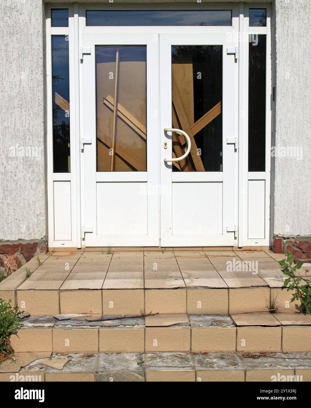 Closed and abandoned store. Lockdown. Old porch with broken tiles and ...