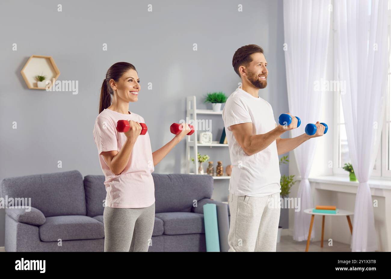 Happy family couple having fitness workout at home and doing exercises ...