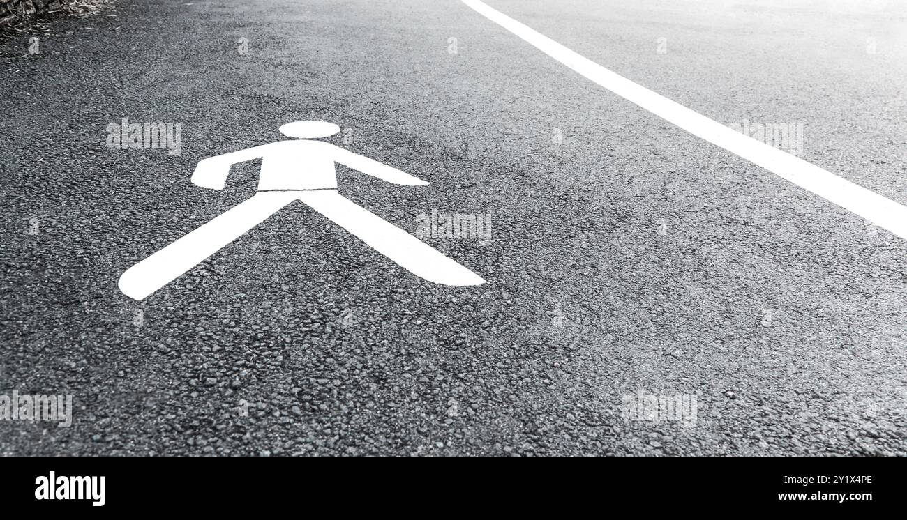 Pedestrian crossing sign. A man walks along the street painted as a ...