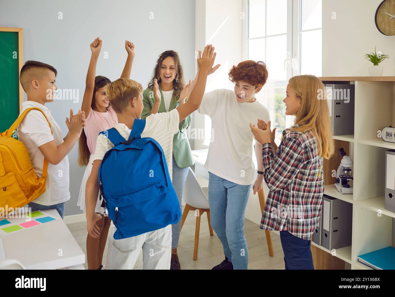 Group of friendly schoolchildren in class high-fiving each other Stock ...