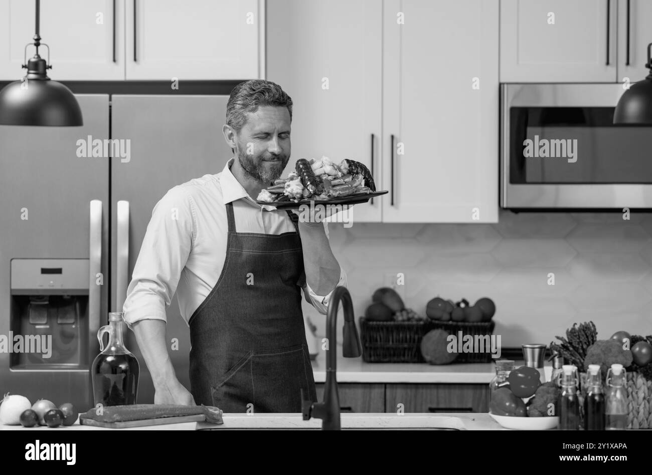 Millennial hispanic man in cook apron hold seafood at kitchen. Cooking ...