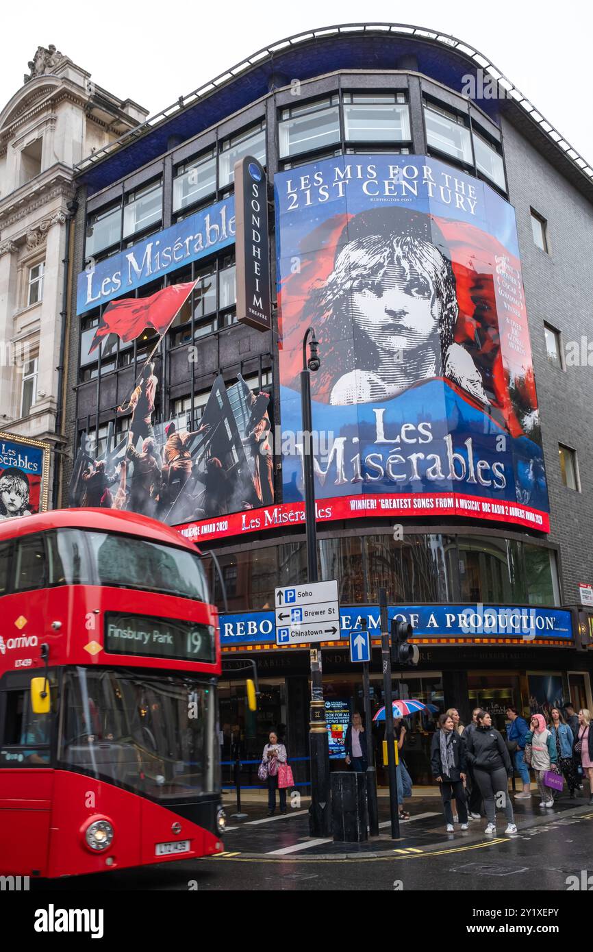 A red London bus driving past the Sondheim Theatre, home of Les ...