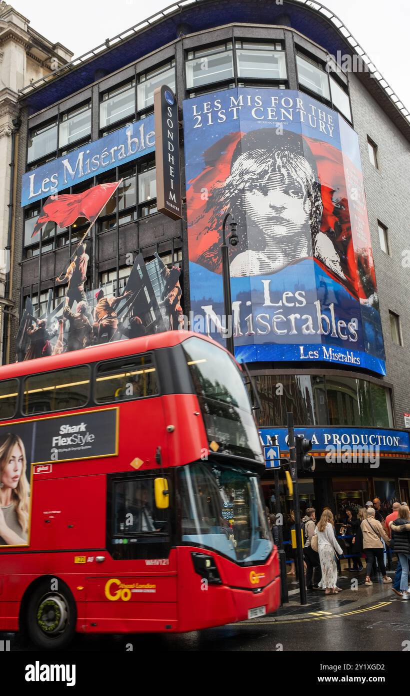 A red London bus driving past the Sondheim Theatre, home of Les ...