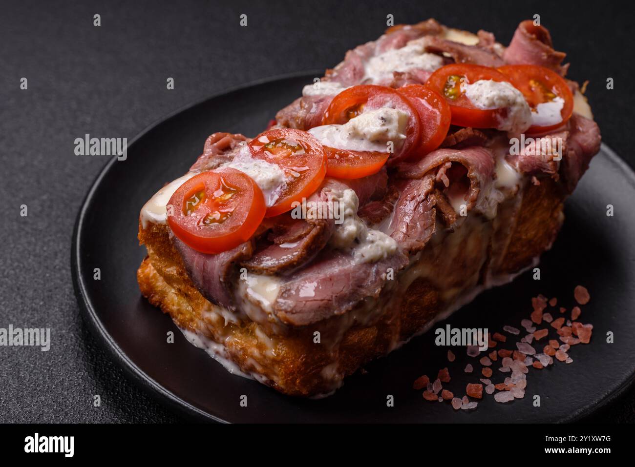 Sandwich with brioche bun, roast beef, tomatoes, stracciatello and ...