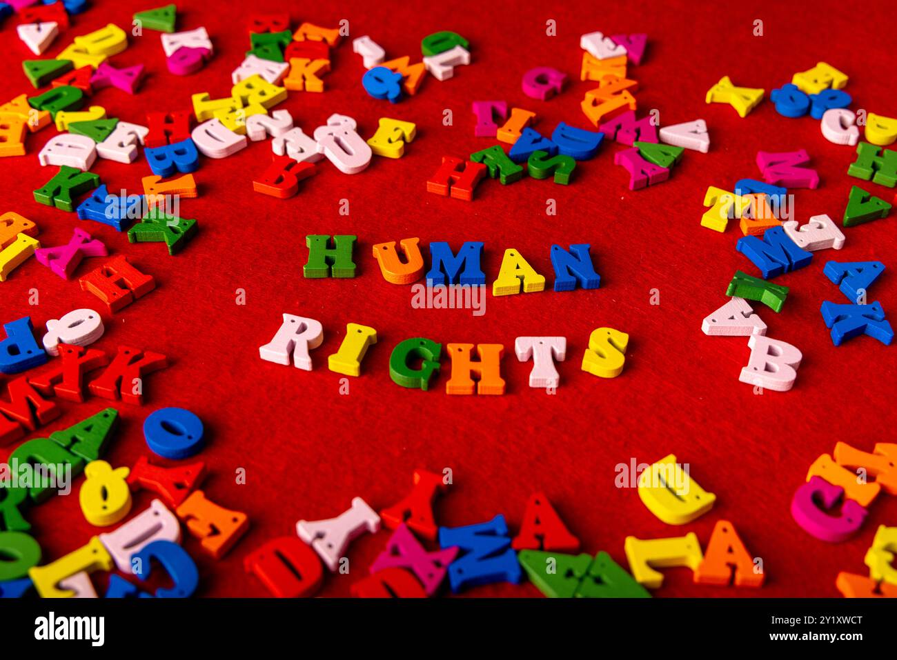 Vibrant wooden letters in the center of a red background form the ...