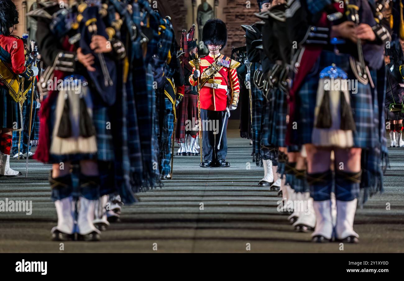 Soldiers wearing kilts playing bagpipes with a soldier wearing a ...