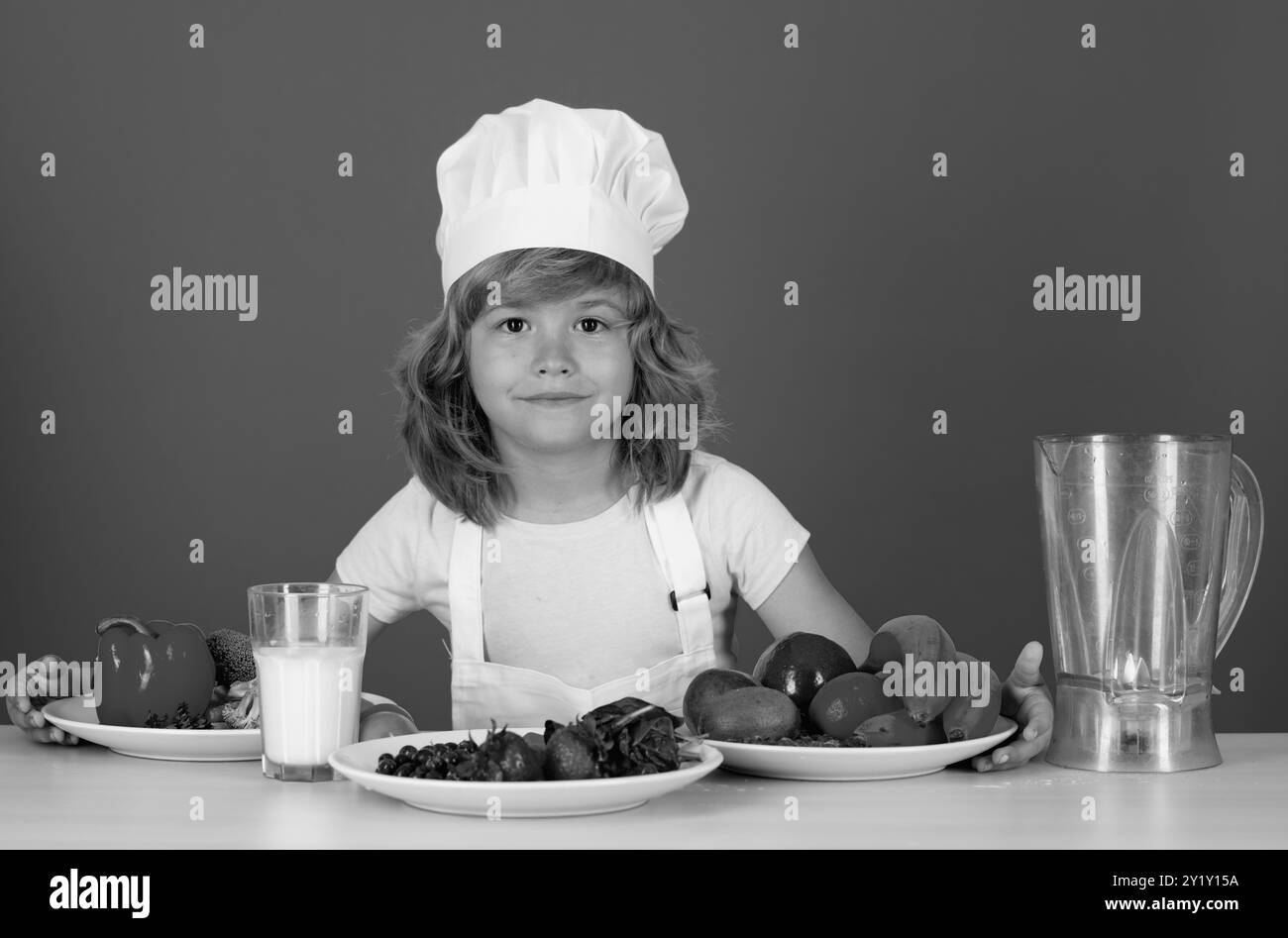Cooking children. Chef kid boy making fresh vegetables for healthy eat ...