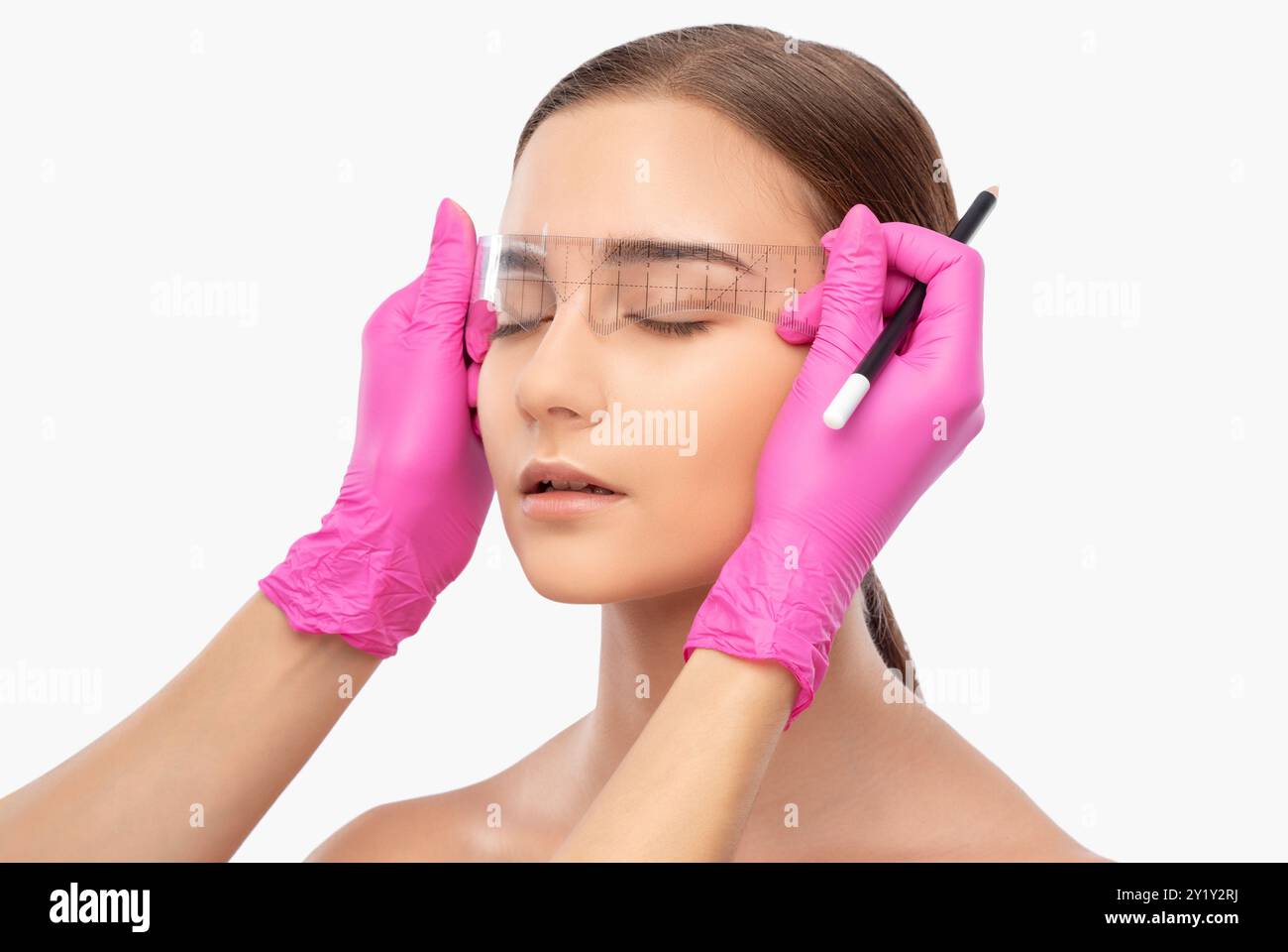 Make-up artist makes markings with white pencil for eyebrow and paints ...