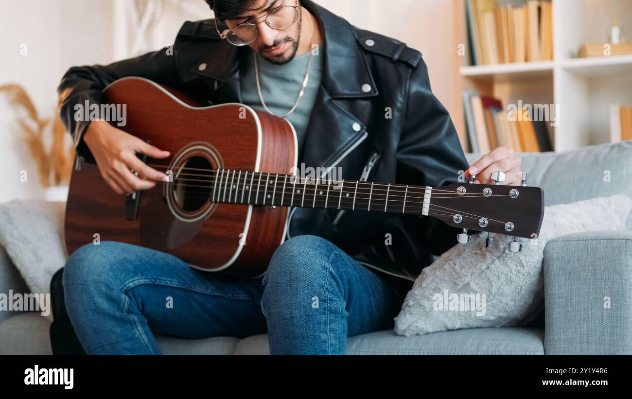 Guitar playing. Creative hobby. Inspired musician guy tuning up ...