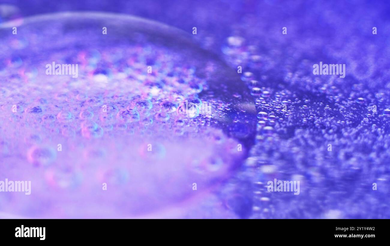Fizzy liquid. Serum gel. Defocused neon purple blue color glitter ...