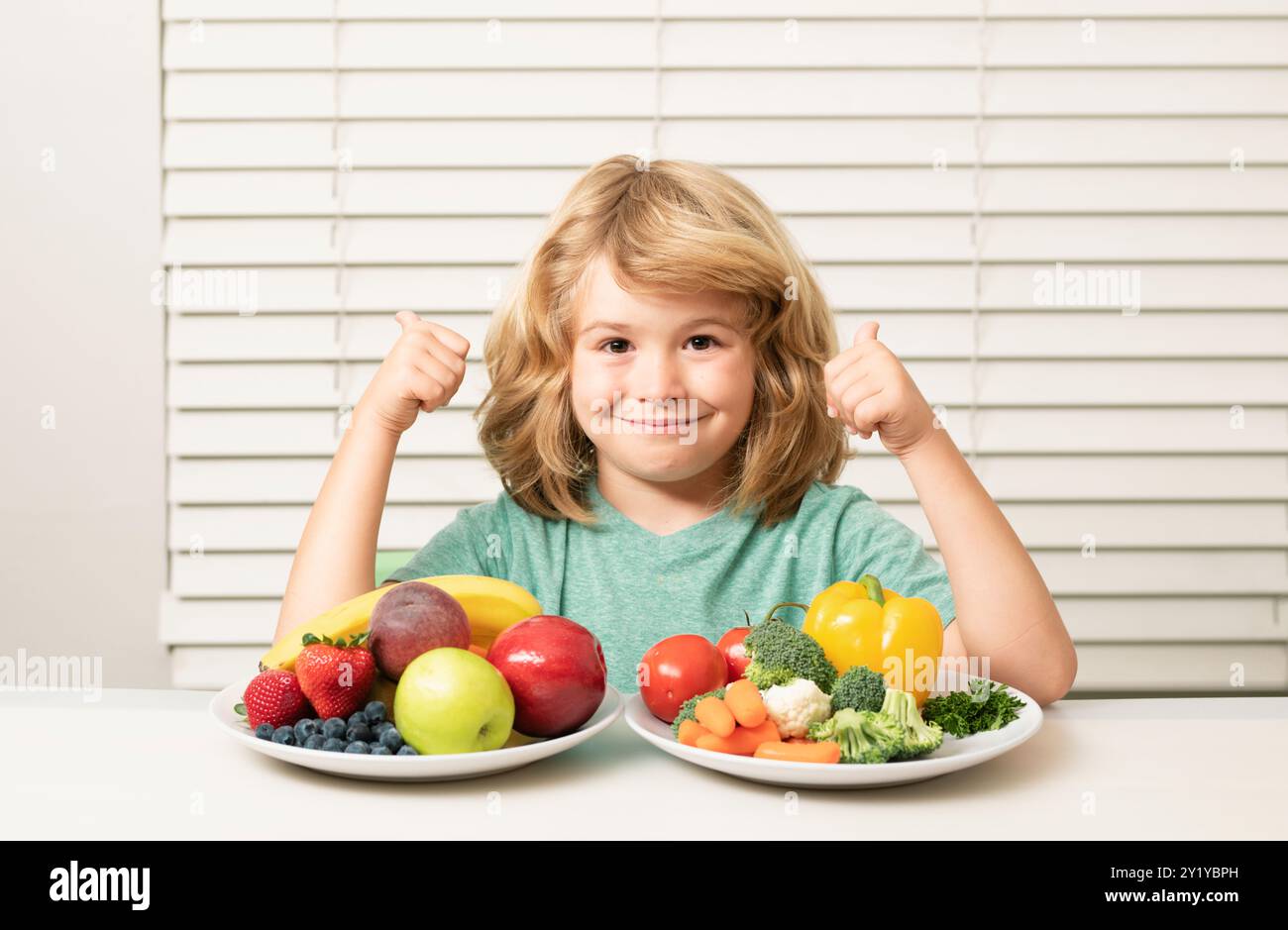 Fruits and vegetables. Funny kid boy having breakfast. Milk, vegetables ...
