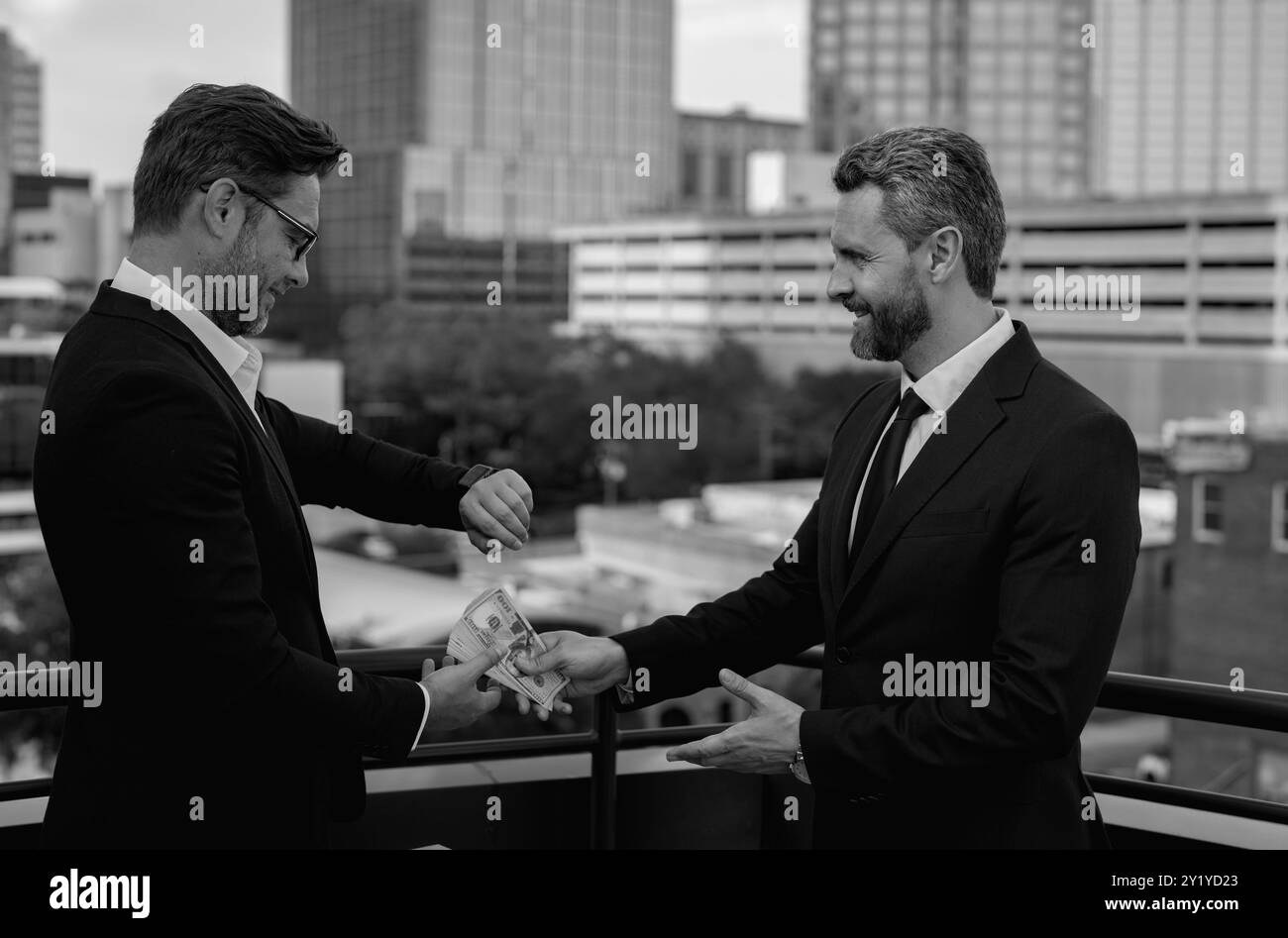 Businessman giving money to his partner outdoor. Businessman giving ...