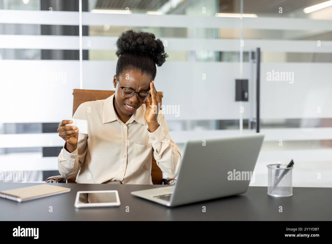 Young businesswoman experiencing headache while working on project. She ...