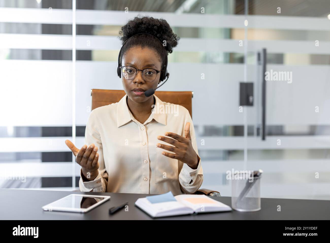 Confident African American businesswoman wearing headset engaged in ...