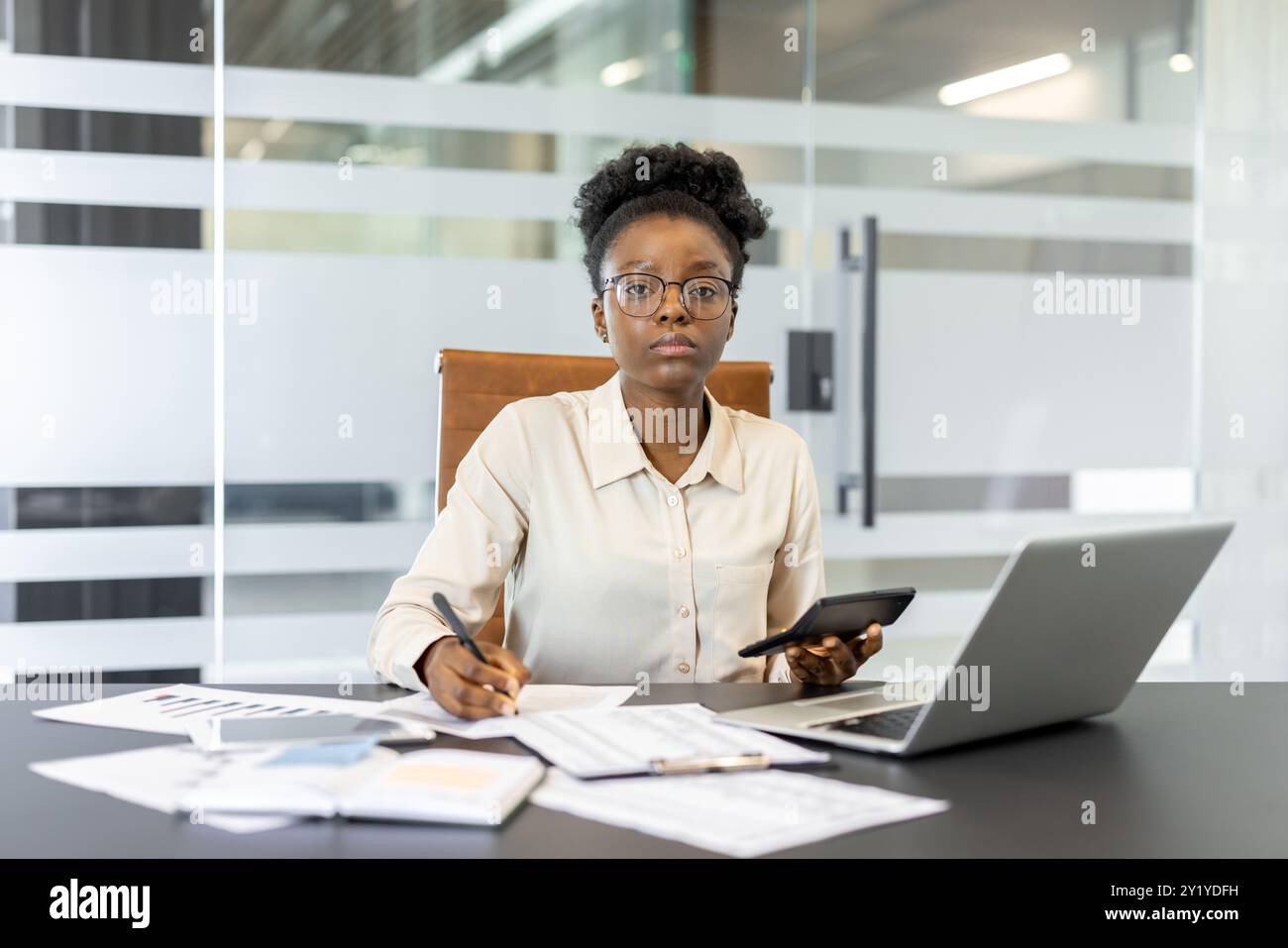 Confident financier using calculator for financial calculations ...