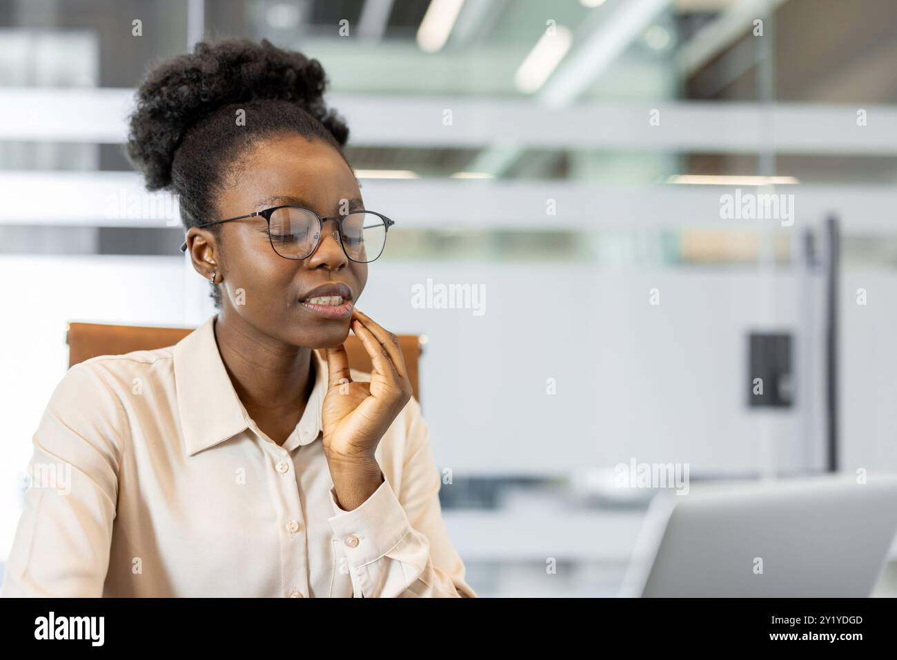 African American businesswoman feeling toothache at office desk. Woman ...