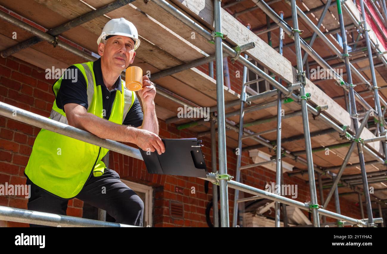 Male builder construction worker or architect on site holding a ...