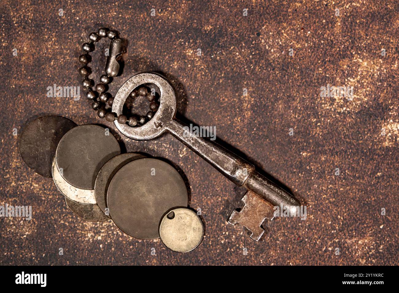 Old, antique coins worn from use with a skeleton key Stock Photo - Alamy