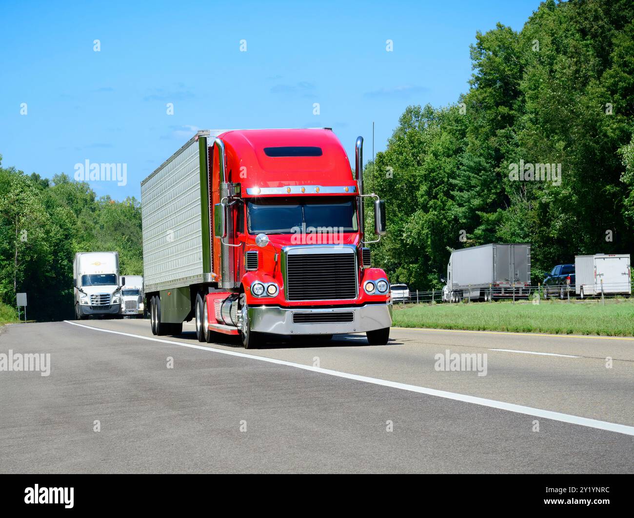 Horizontal shot of a red eighteen wheeler semi truck on a crowded ...