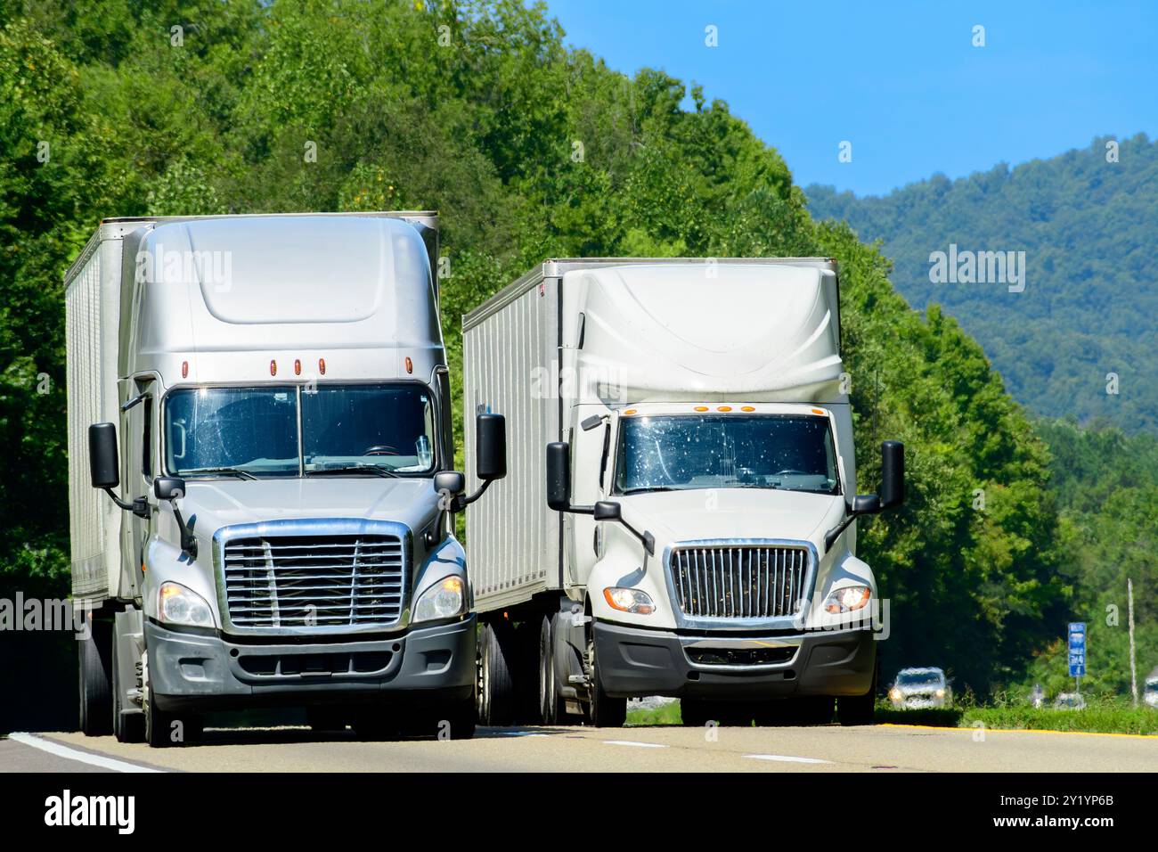 Horizontal shot of two eighteen wheeler semi trucks going down the ...