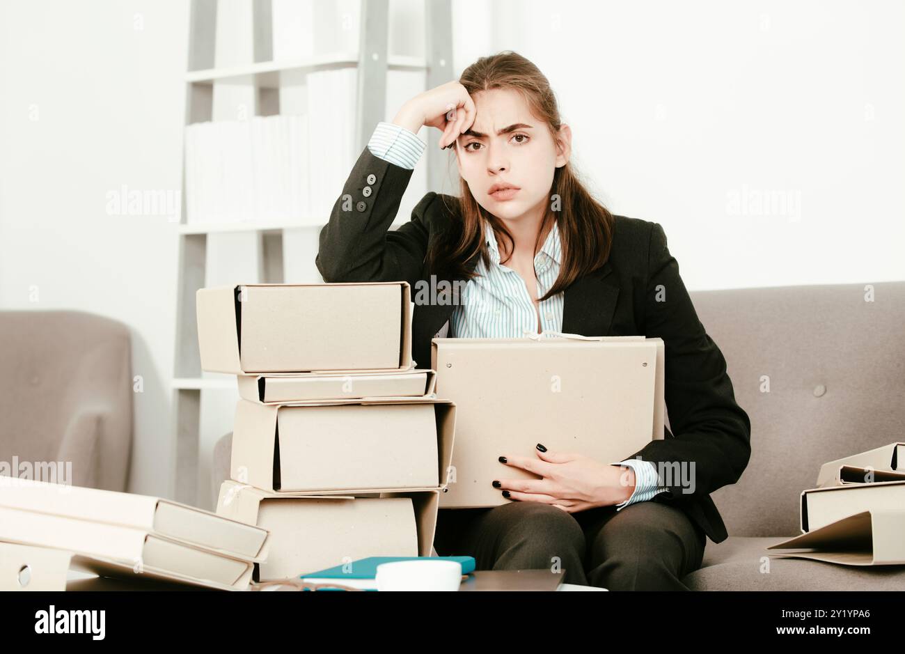 Sadness depressed businesswoman with many folders of documents ...