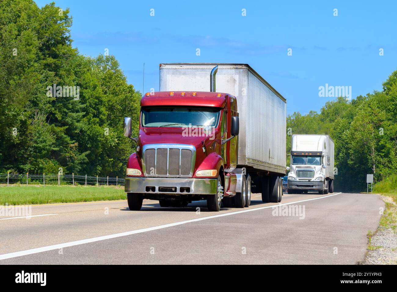 Horizontal shot of eighteen wheeler trucks going down a Tennessee ...