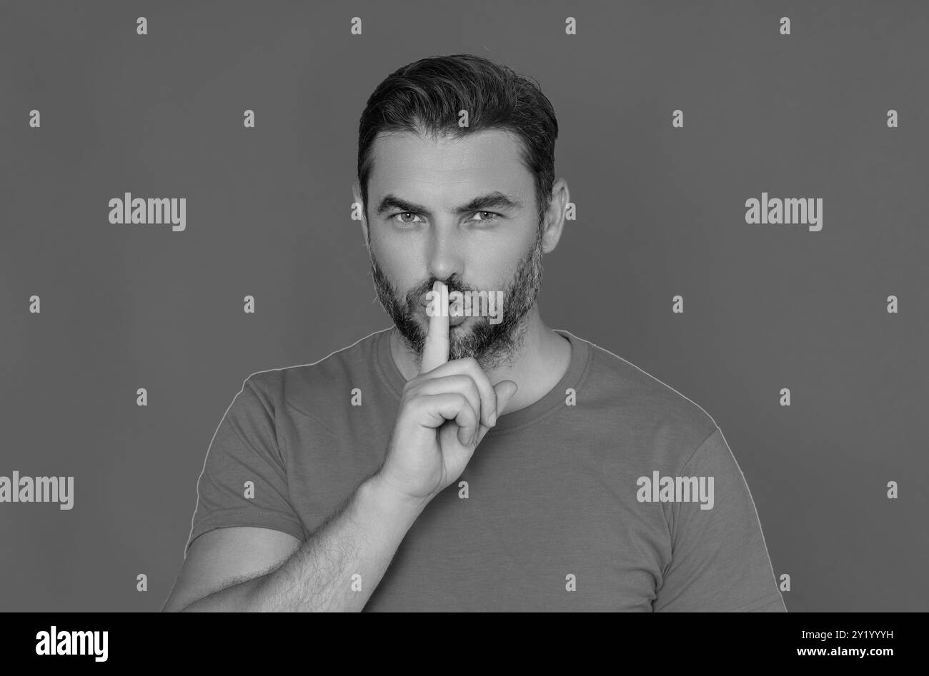 Guy having secret and holding finger on lips. Male model, asks to be ...