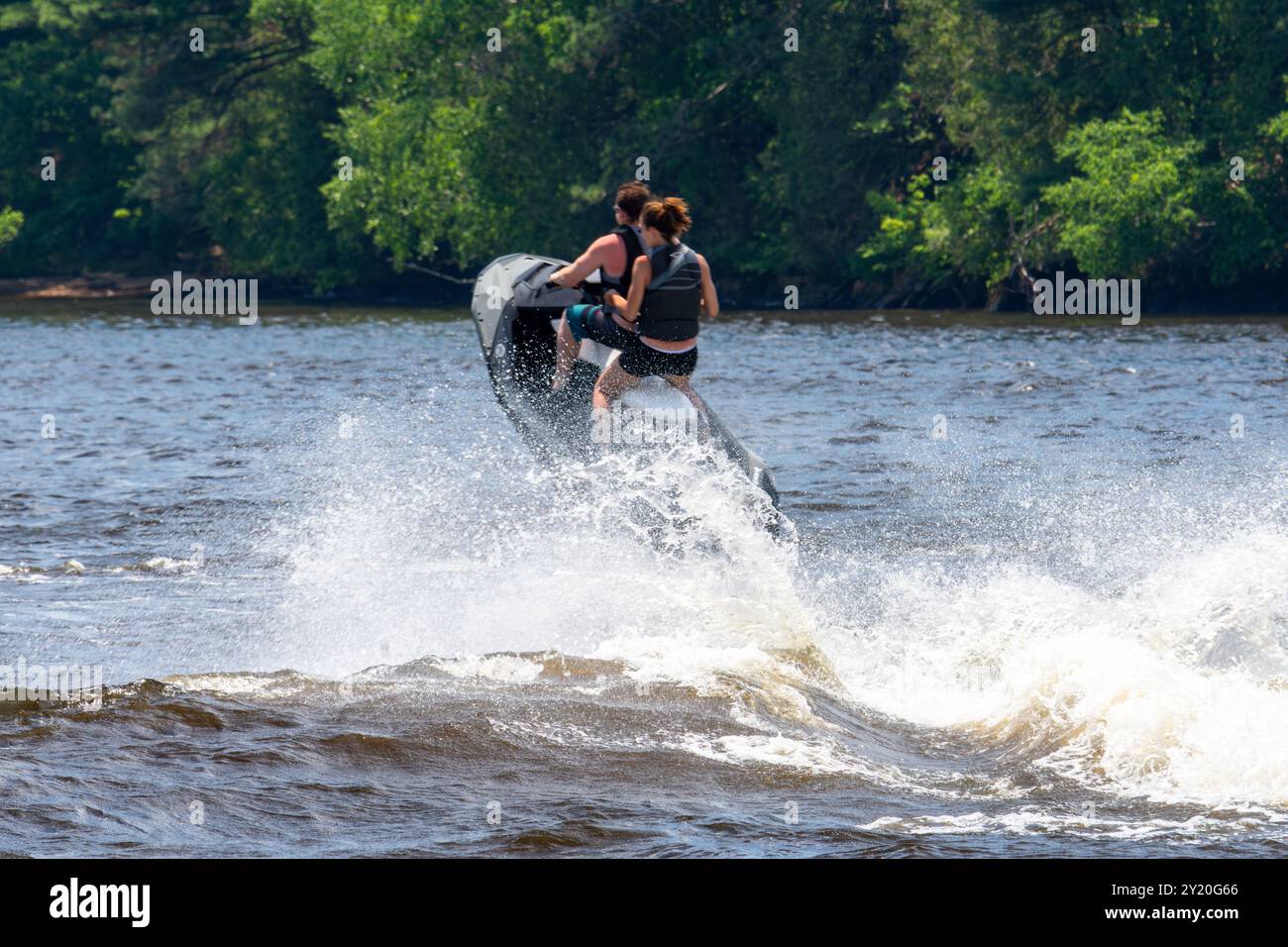 A man and a woman ride tandem on a jet ski on the Wisconsin River near ...