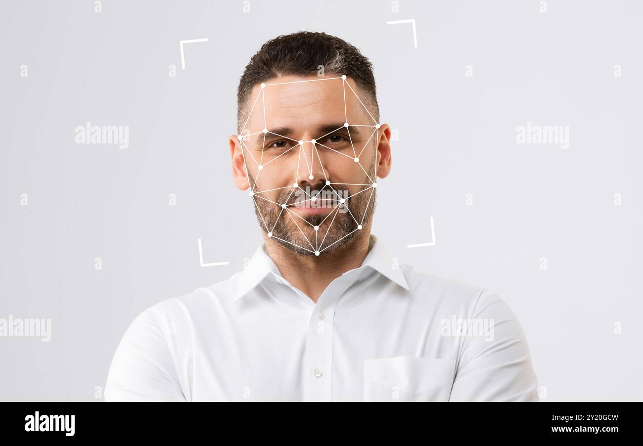 Confident man with facial recognition overlay on a light background ...