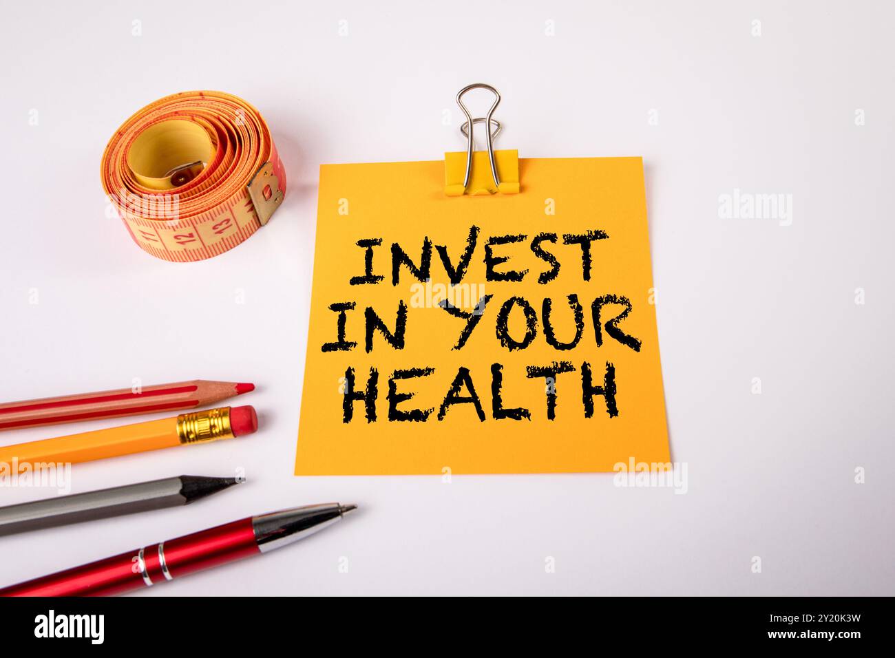 Invest in your health. Measuring tape and notepad with text on a white ...