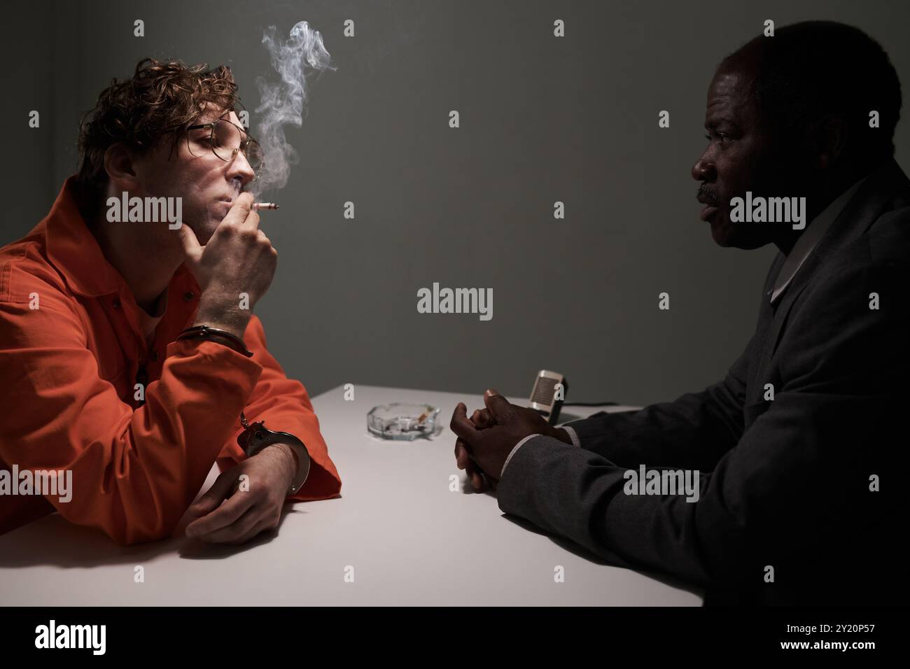 Two men sitting across from each other discussing legal matters in a ...