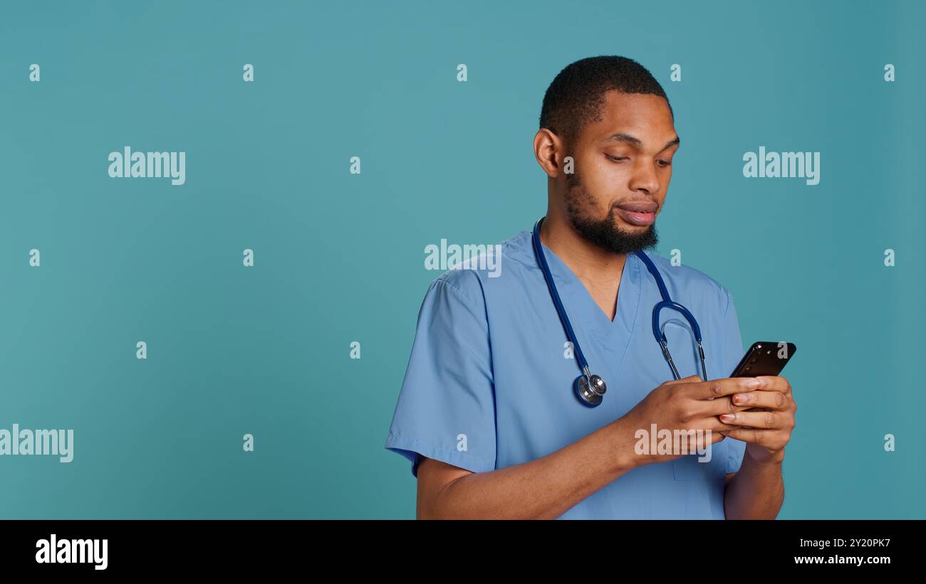 Male nurse using mobile phone to scroll on social media feed during ...