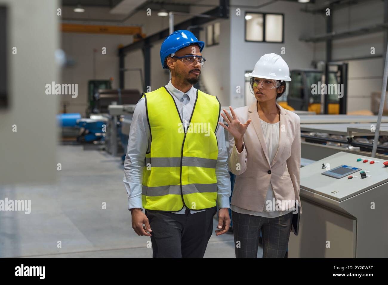 Indian female factory manager introducing the production line to a ...